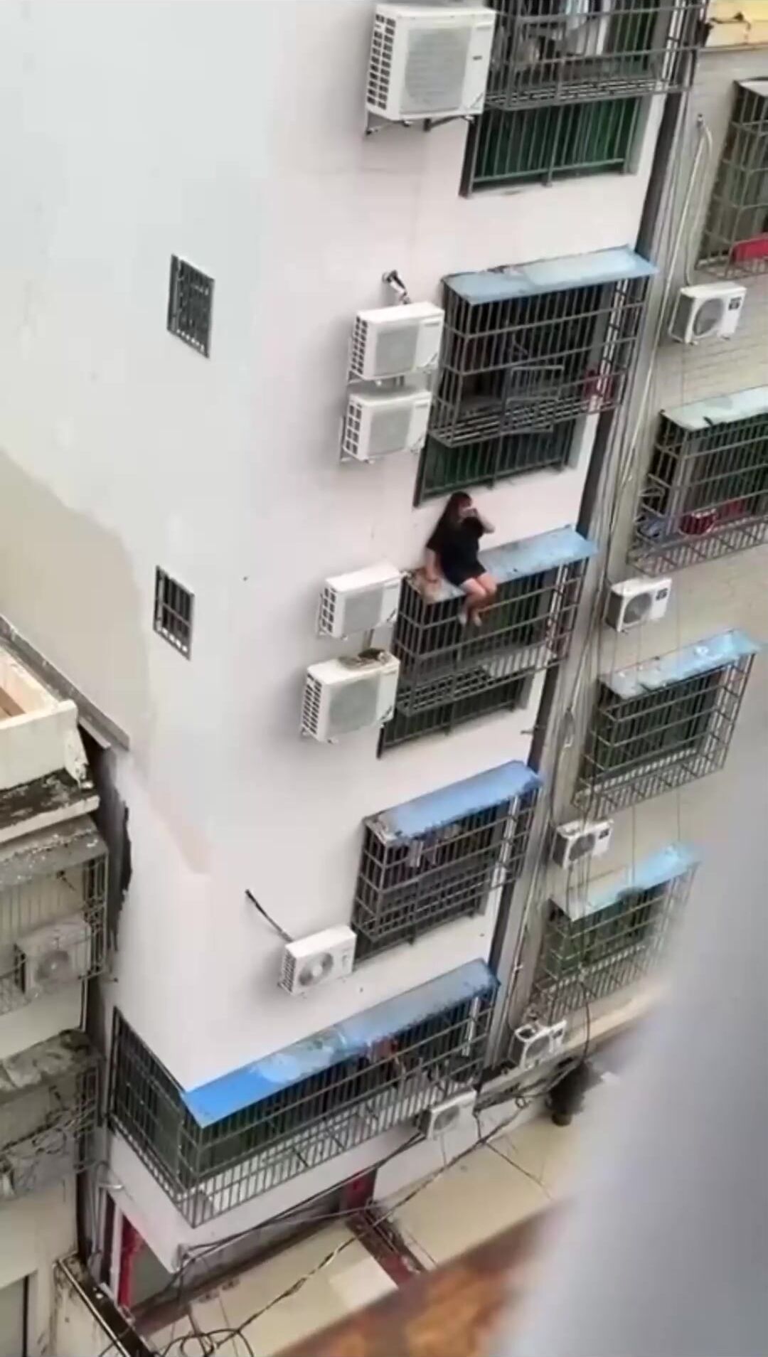 Crazed Girl Falls Off Apartment Cage In China