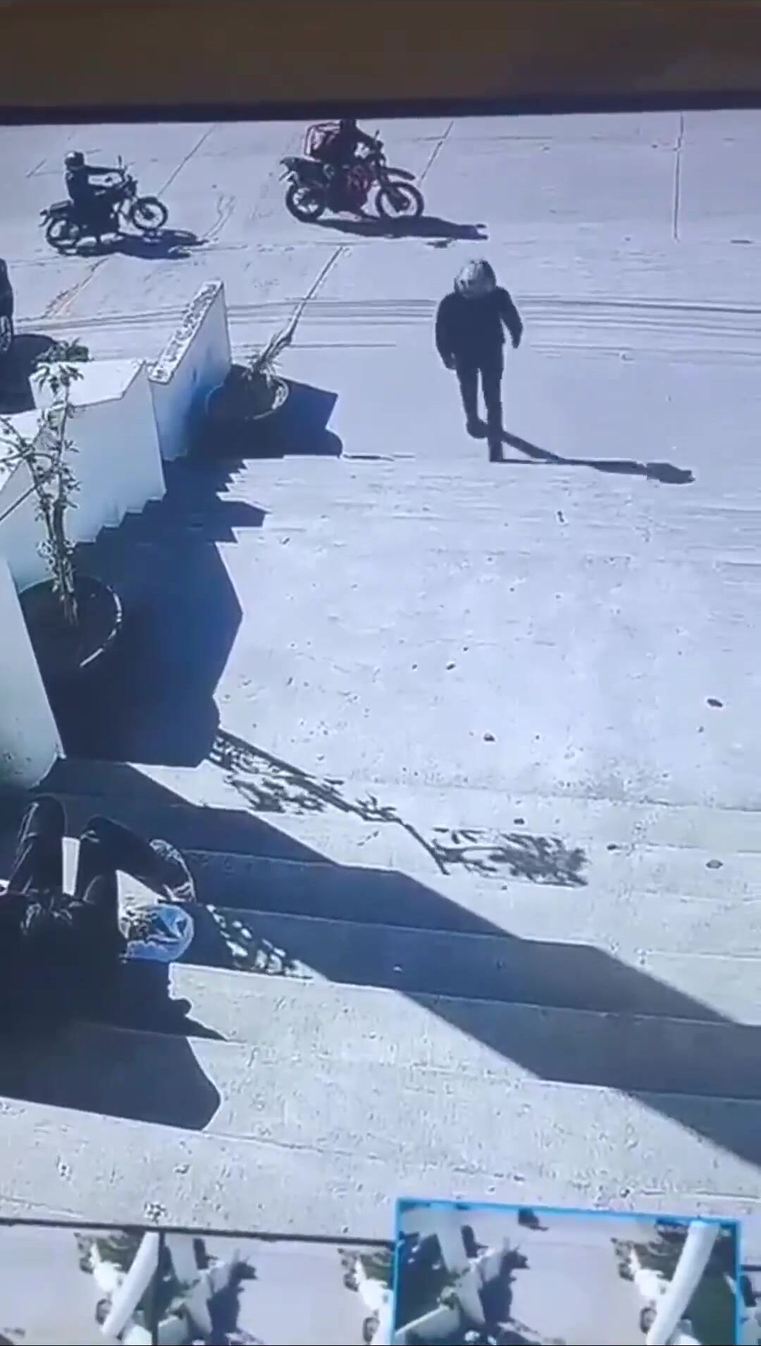 Two Men Sitting On The Steps Shot By Helmet Wearing Hitman